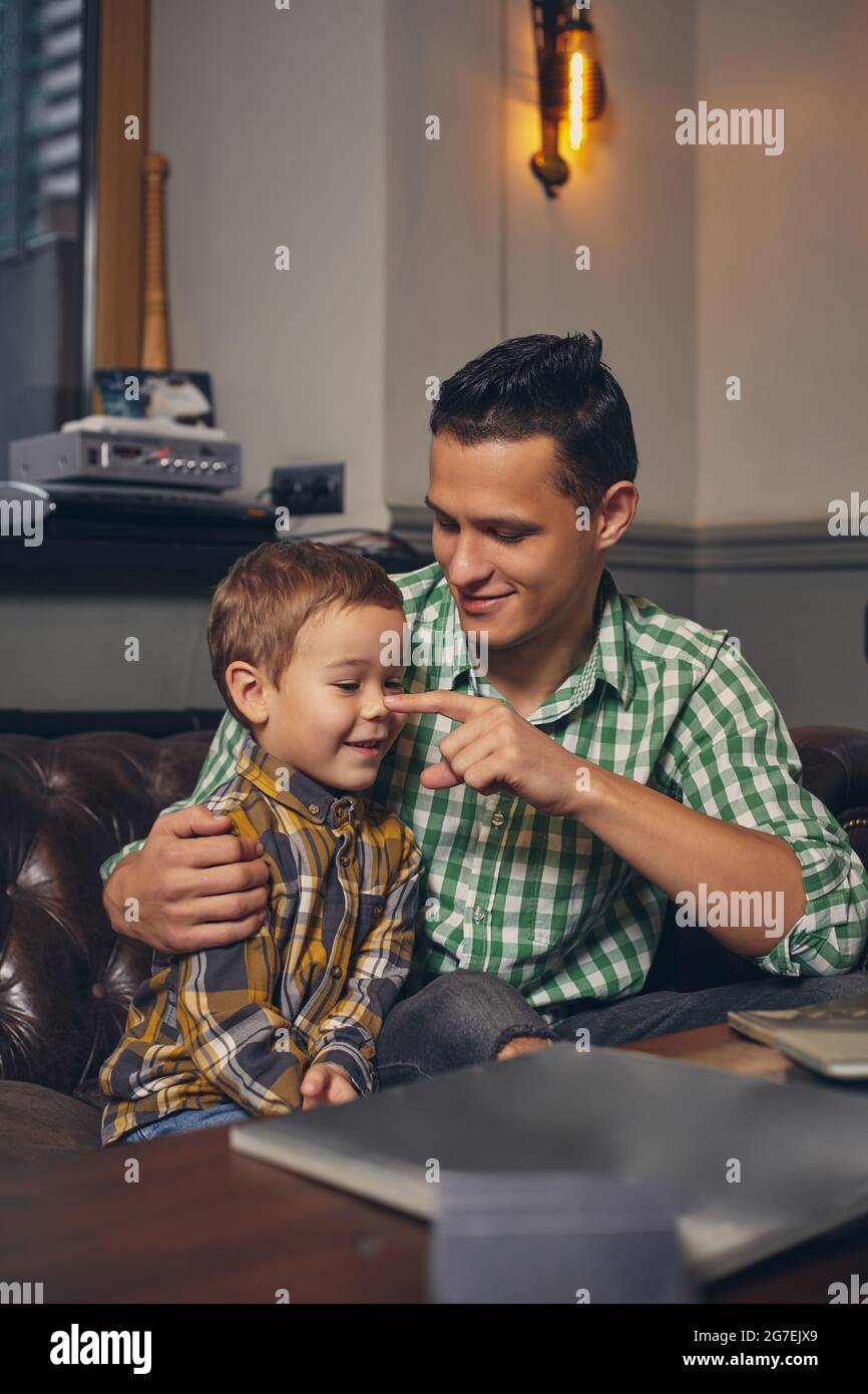 Young father and his stylish little son in the barbershop in the ...