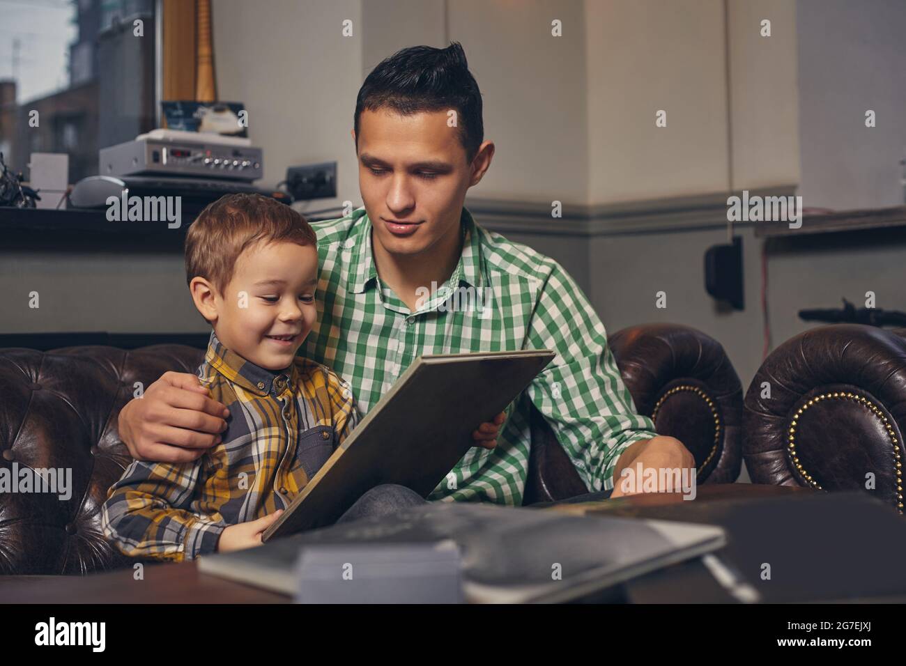 Young father and his stylish little son in the barbershop in the ...