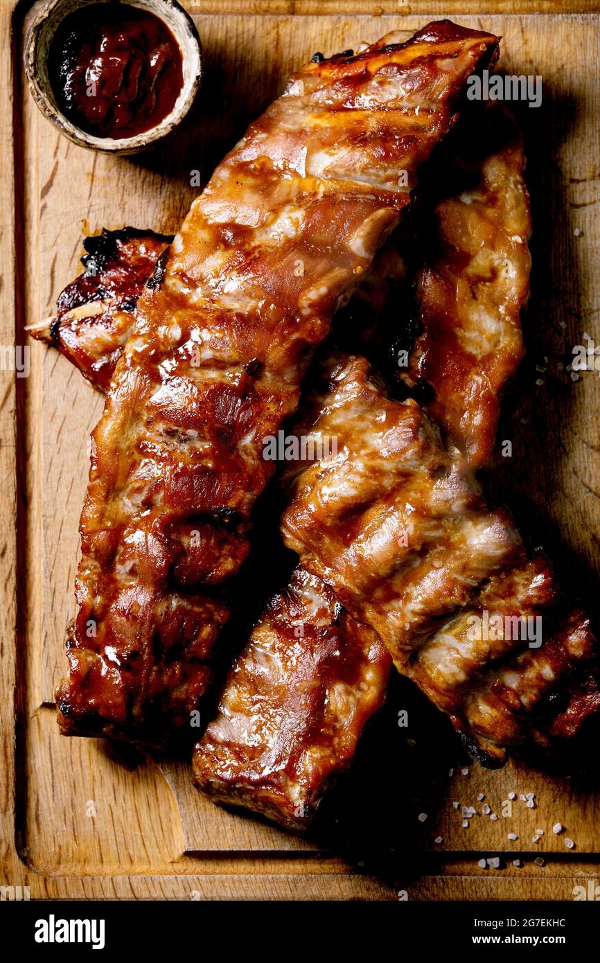 Grilled pork bbq ribs served barbeque sauce on wooden cutting board ...