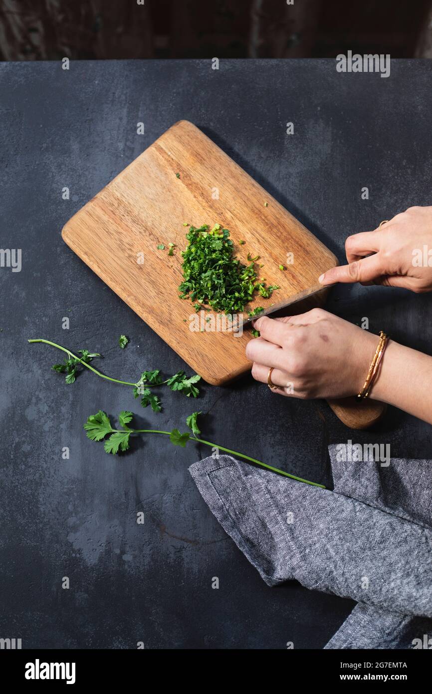 Coriander, Finely chopped on a chopping board in a slate kitchen ...
