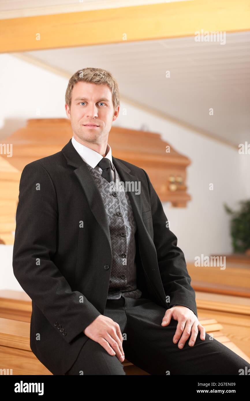 Undertaker in his store with a display of coffins Stock Photo - Alamy