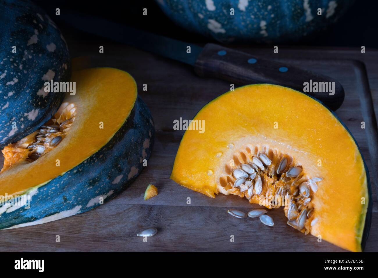 Pumpkin cut into slices on a chopping board Stock Photo - Alamy