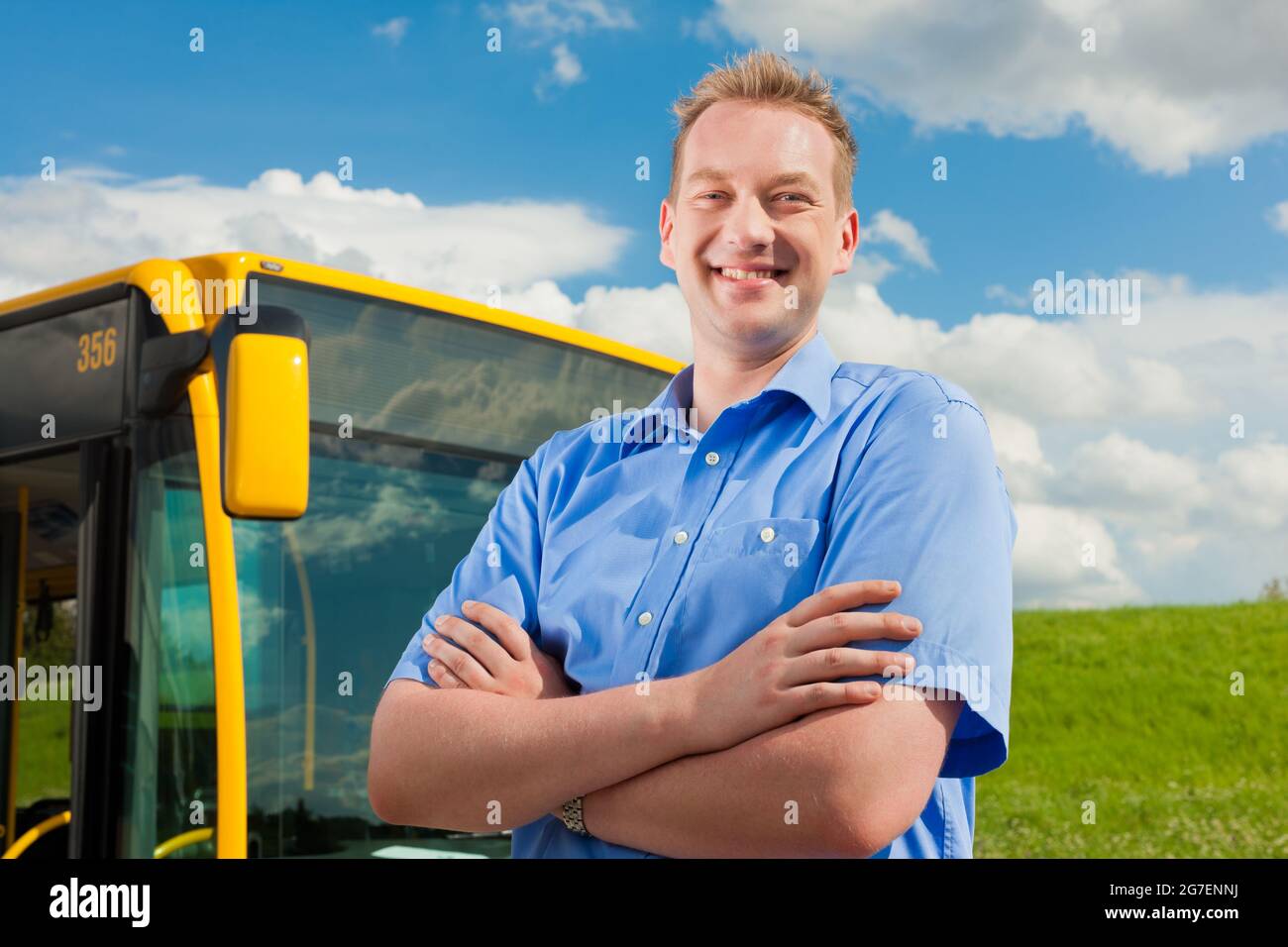 Bus driver is standing in front of his bus under al blue sky Stock ...