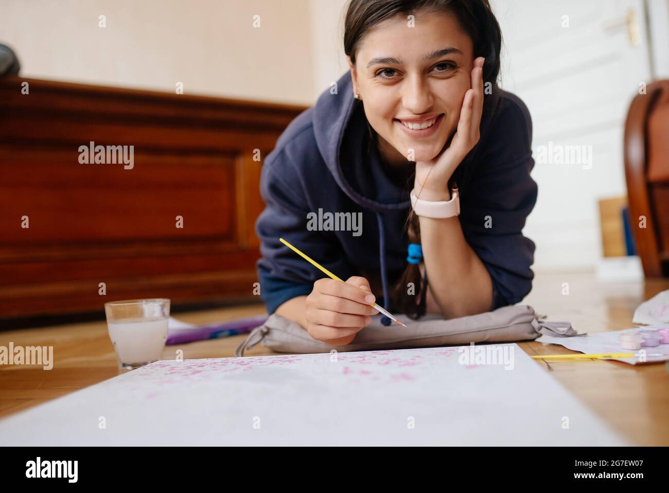 Young woman drawing laying on the floor at home Stock Photo - Alamy