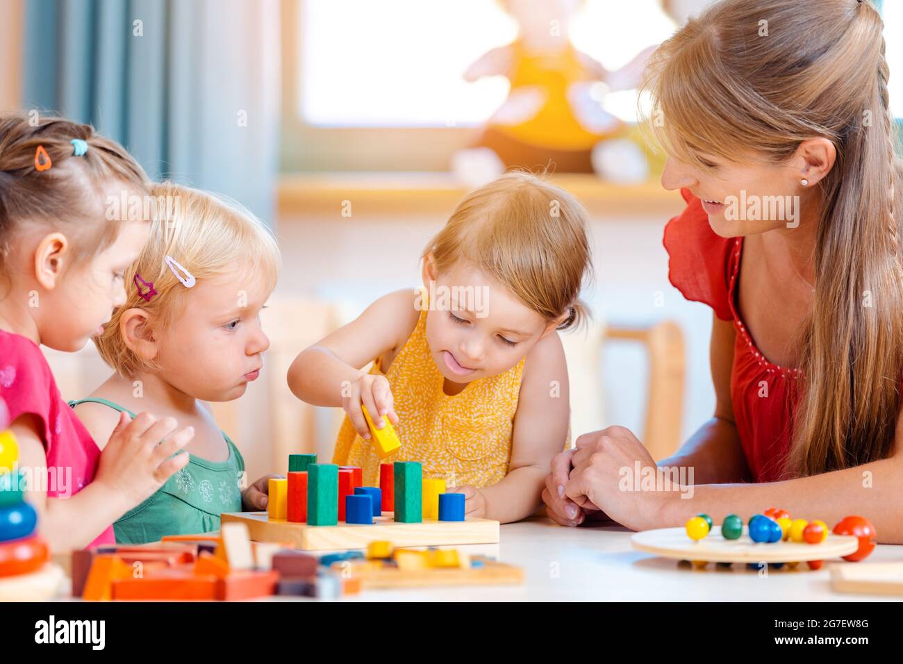Group of children and teacher playing practical games in kindergarten ...