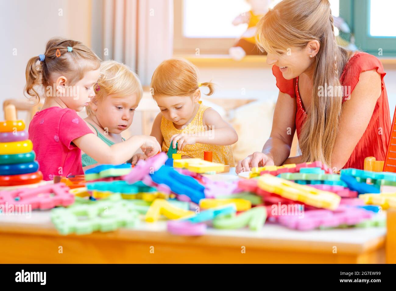 Group of children and teacher playing practical games in kindergarten ...