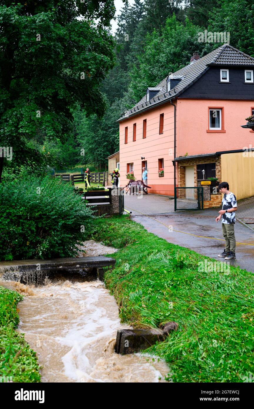 Naila, Germany. 13th July, 2021. Firefighters pump out a fully flooded ...