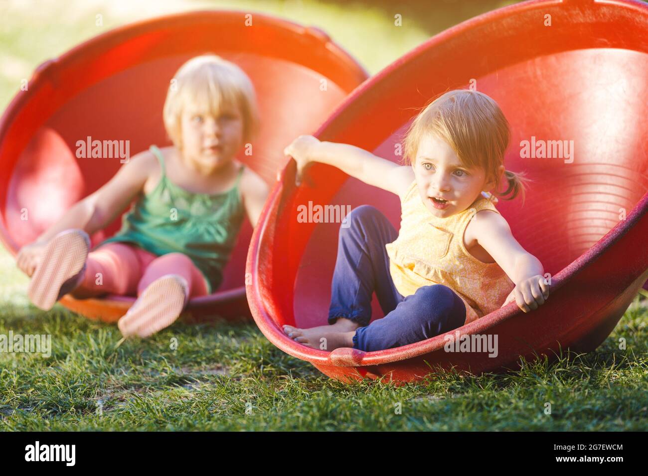 Children playing together outdoors sitting in colorful chairs Stock ...