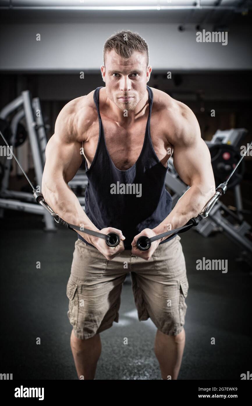 Bodybuilder doing butterfly on cable pull for better definition of his ...
