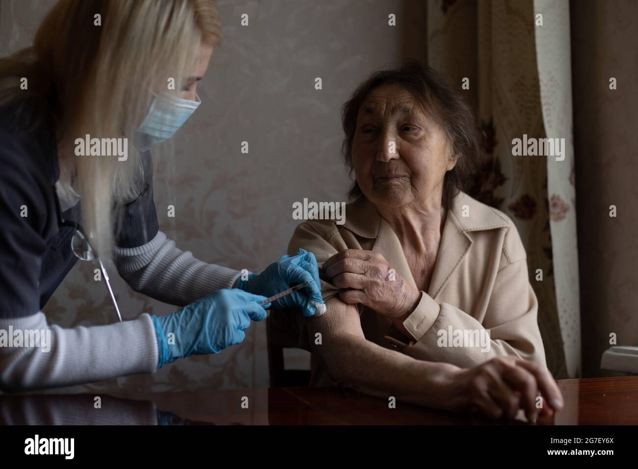Nurse giving an injection to senior woman Stock Photo - Alamy