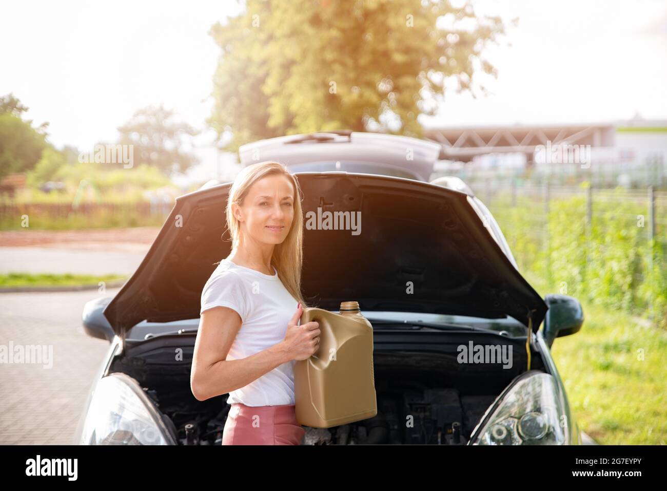 The blonde holds motor oil in her hand Stock Photo - Alamy