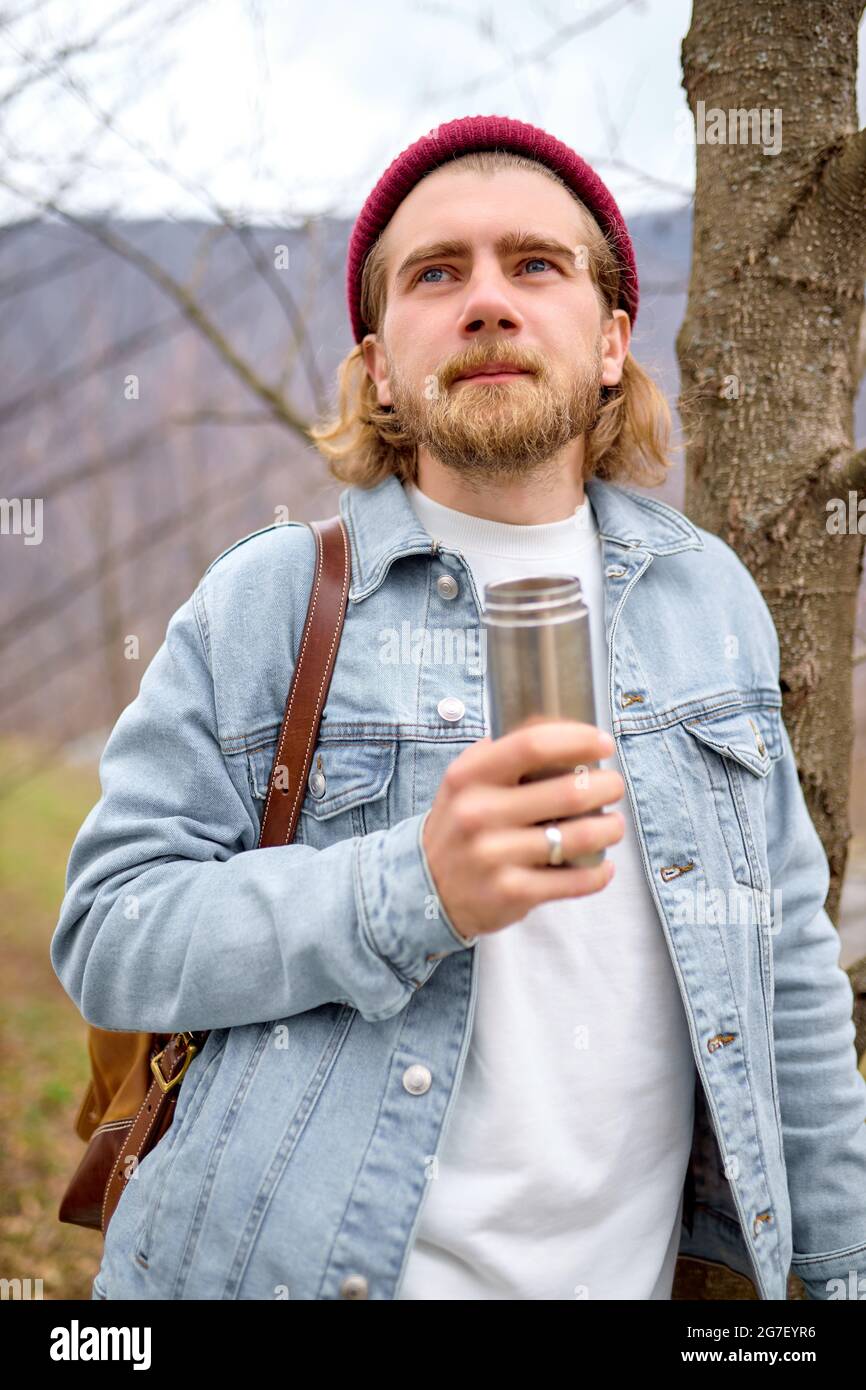 young handsome brutal bearded man traveling in the wild nature with ...