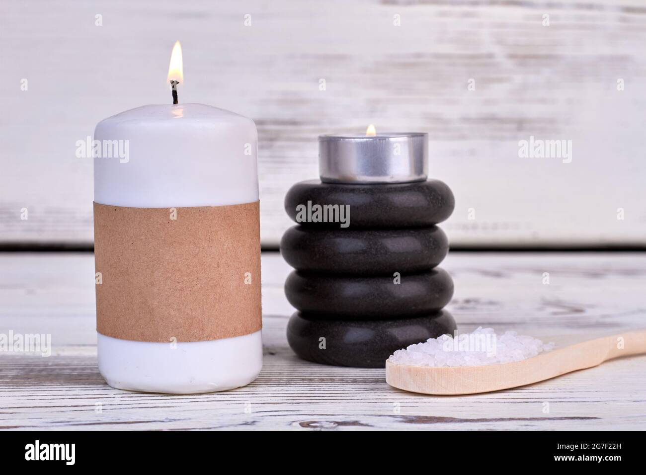 Burning candle with stones and spoon on wooden background Stock Photo ...