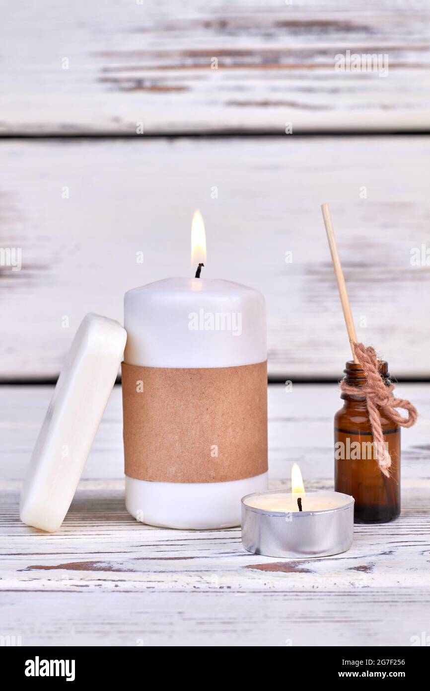 Burning aroma spa candles with glowing lights and bottle of oil Stock ...