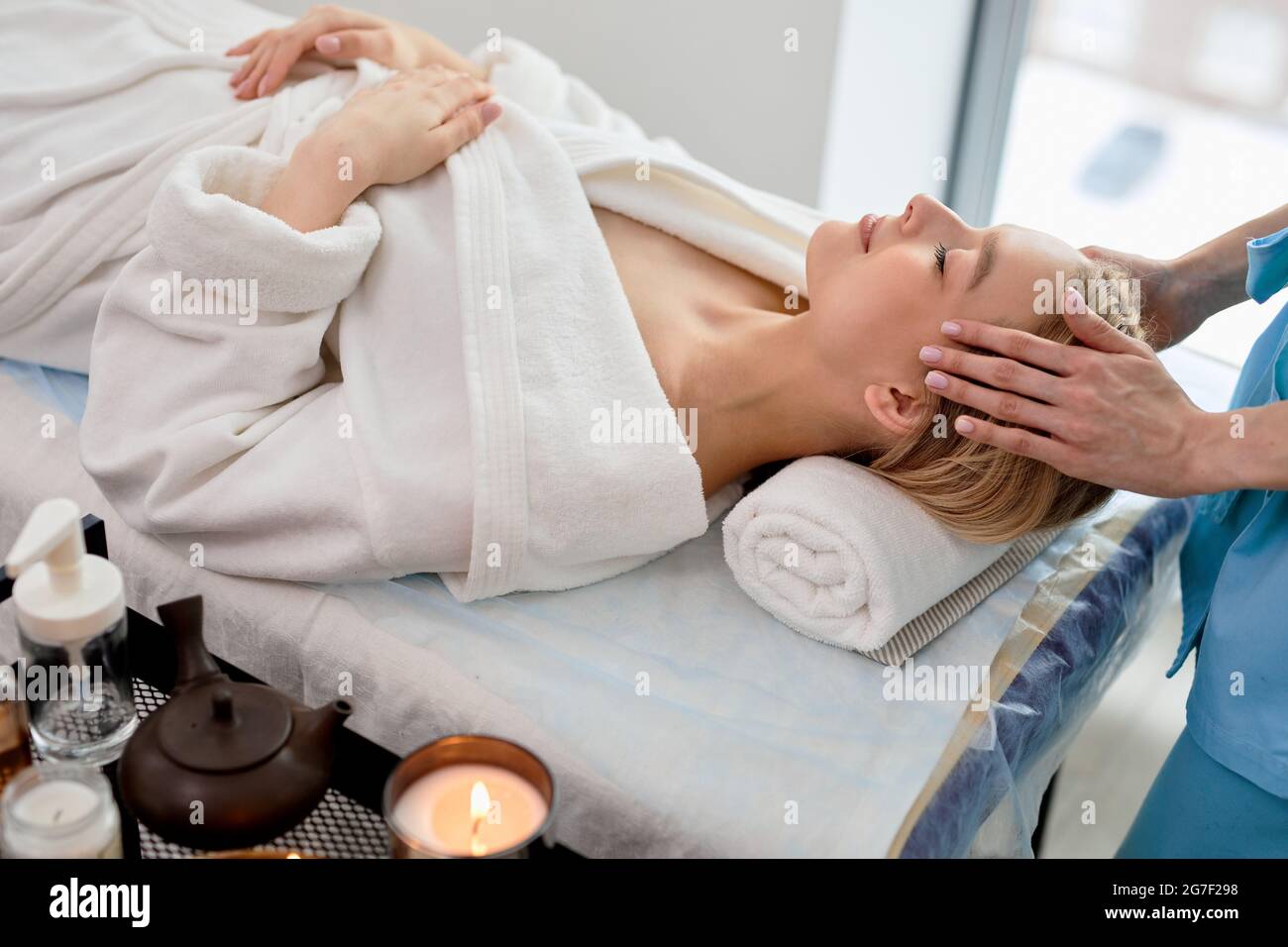 Unrecognizable female masseur in blue wear doing relaxing massage to ...