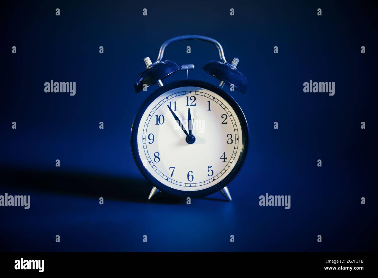 Analog clock front view, dark blue background Stock Photo - Alamy