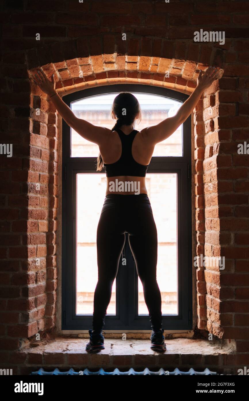 Rear view of muscular young athletic woman with strong beautiful body ...