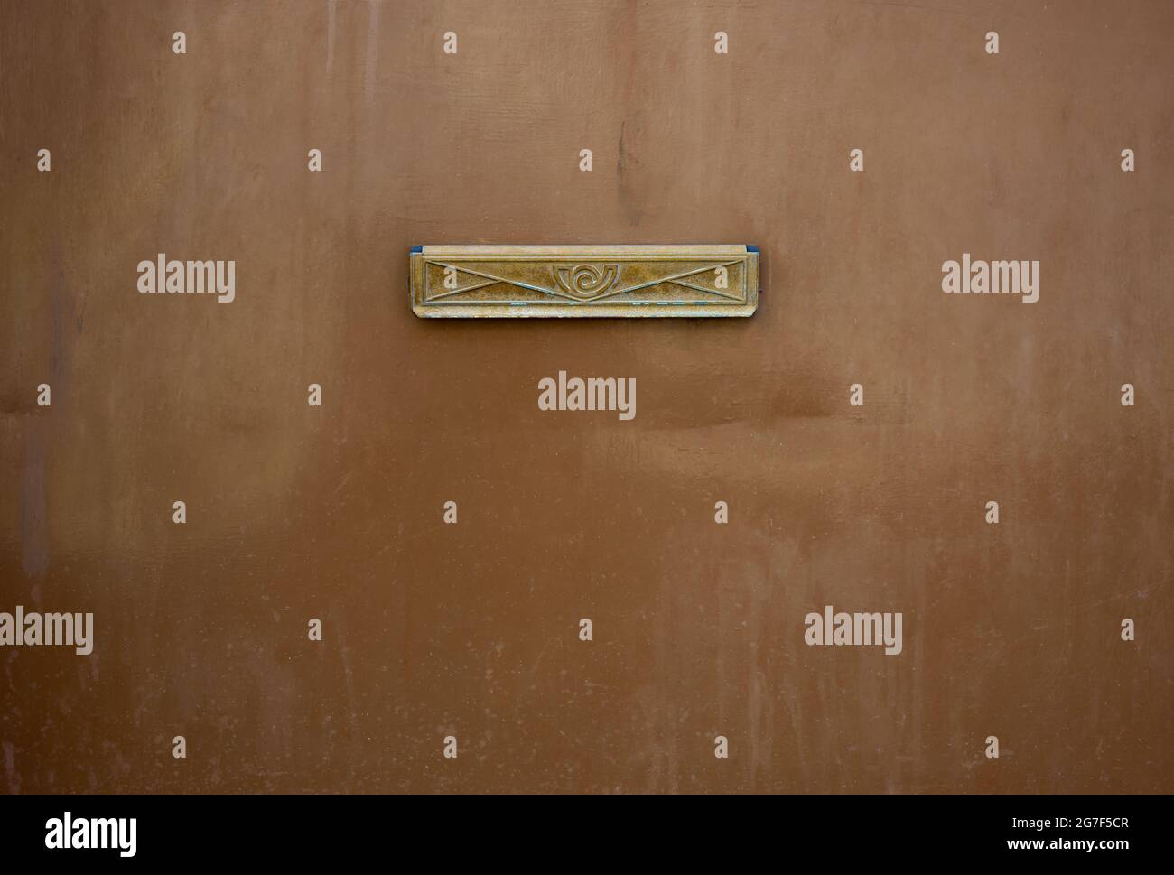 detail of a metal mailbox opening on a brown metal door Stock Photo - Alamy