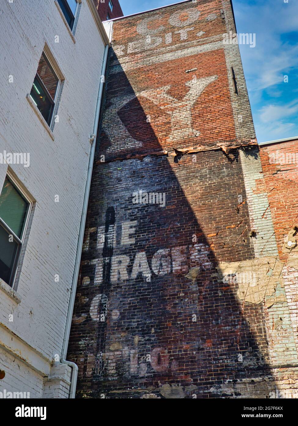 Abandoned buildings with painted signs in city alley Stock Photo - Alamy