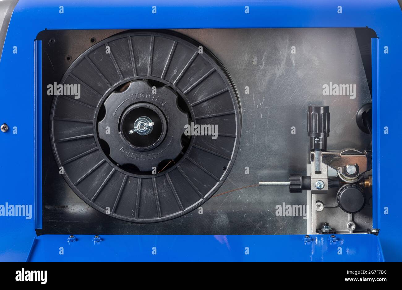 Side panel open on small MIG welder showing installed spool of welding ...