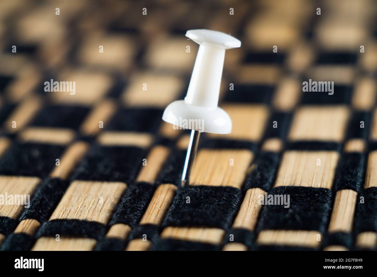Close-up photo of a white push pin fixed in a surface Stock Photo - Alamy