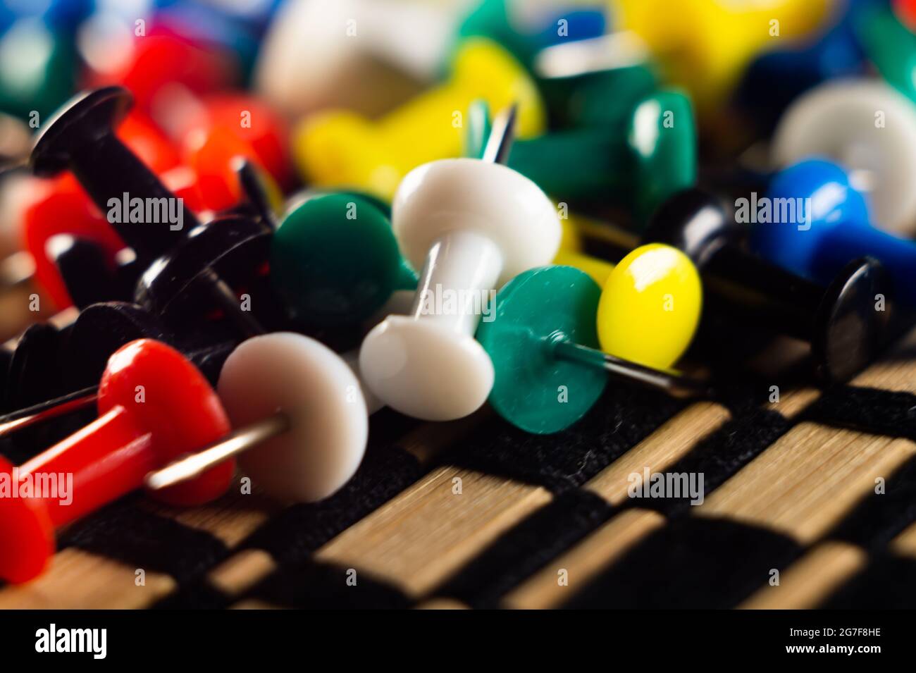Close-up photo of a set of multi-colored push pins scattered on the ...