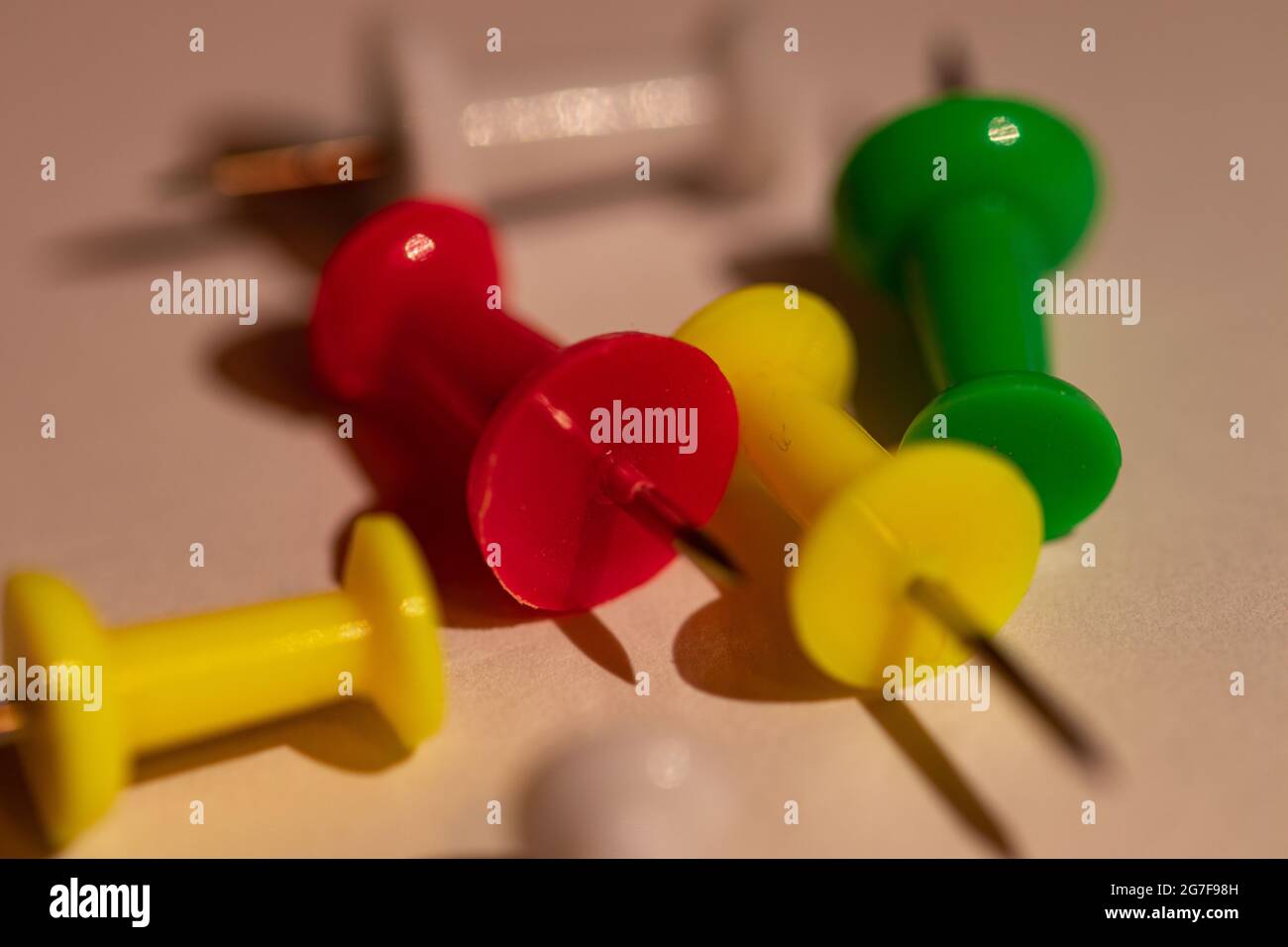 Colorful plastic push pins on a desk Stock Photo - Alamy