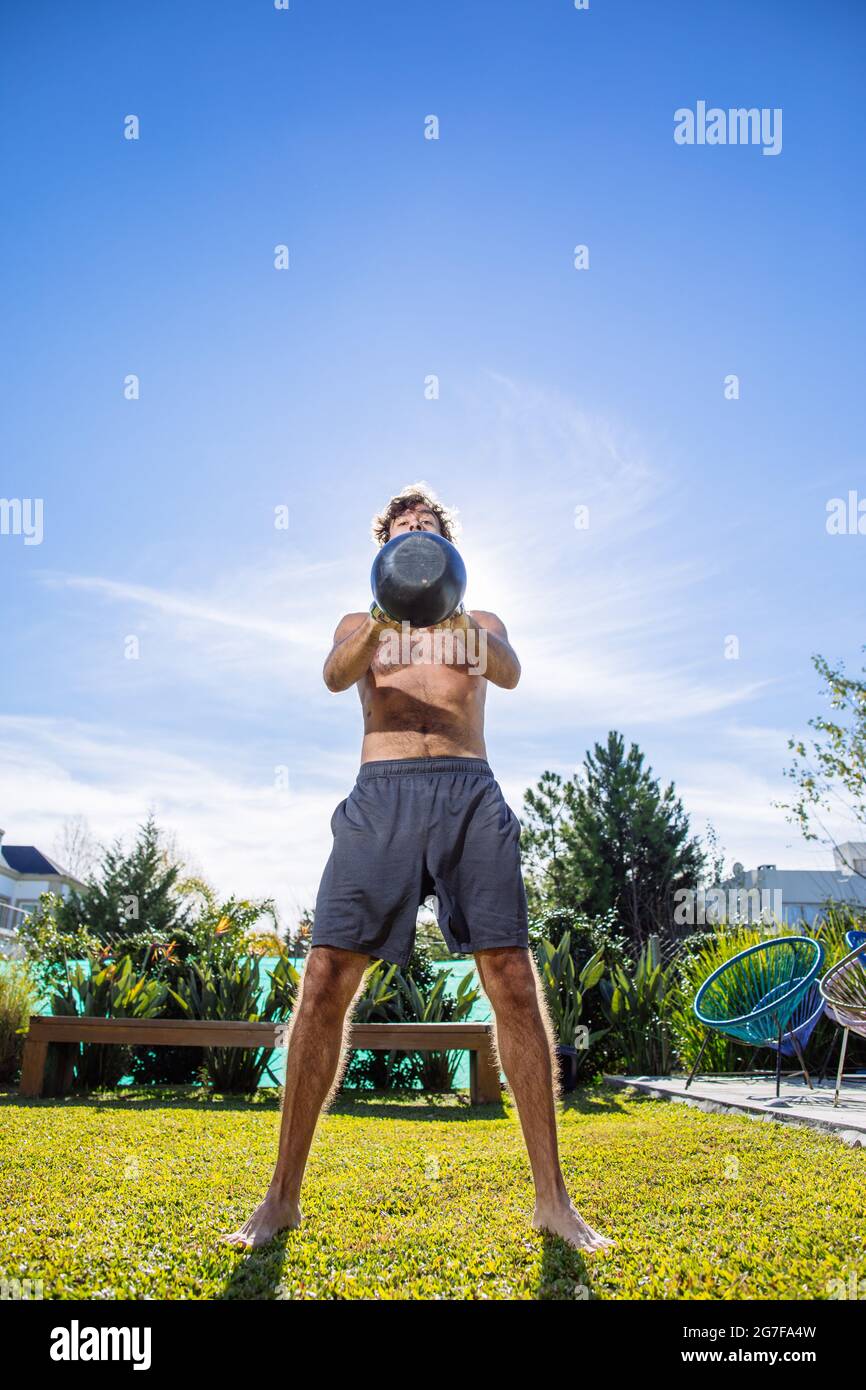 Middle age man training crossfit and weightlifting in his backyard ...