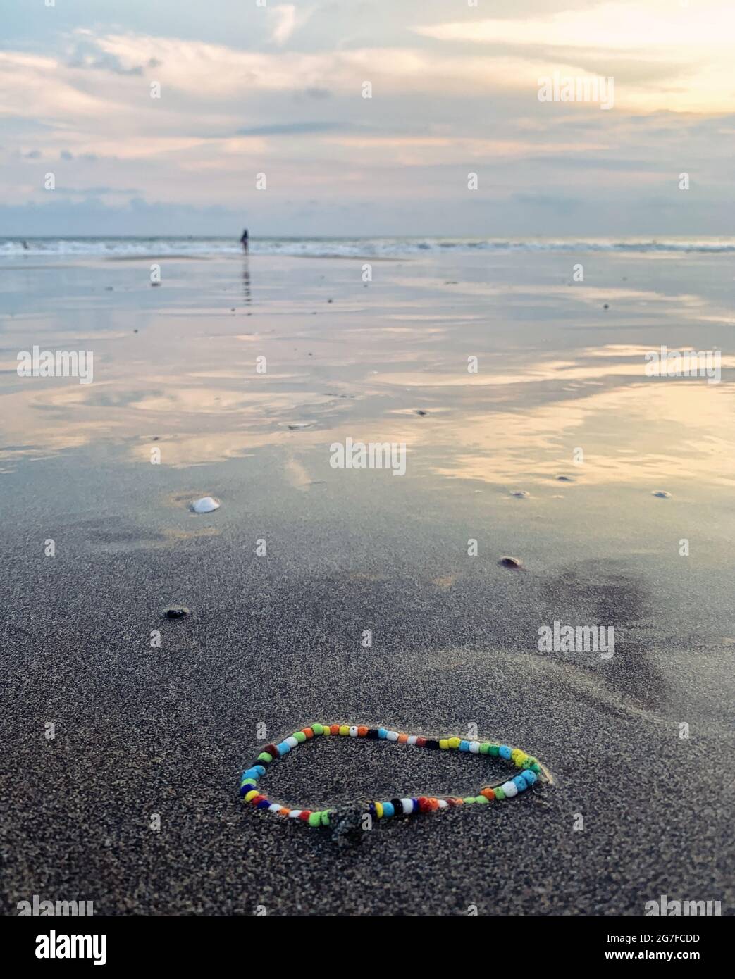 Selective of a colorful string lying on a sandy beach Stock Photo - Alamy