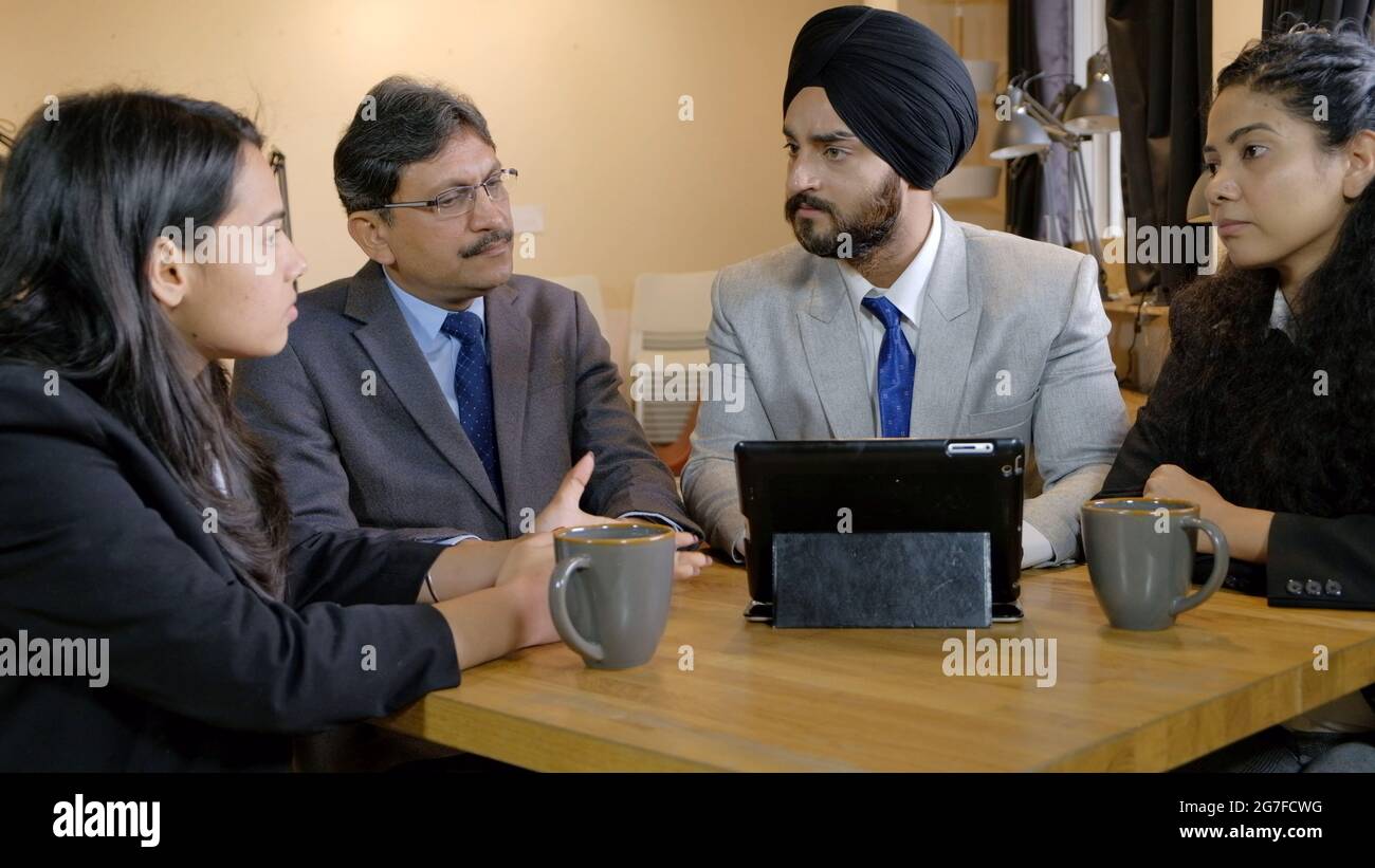 Group of Indian workers brainstorming during a business meeting in ...