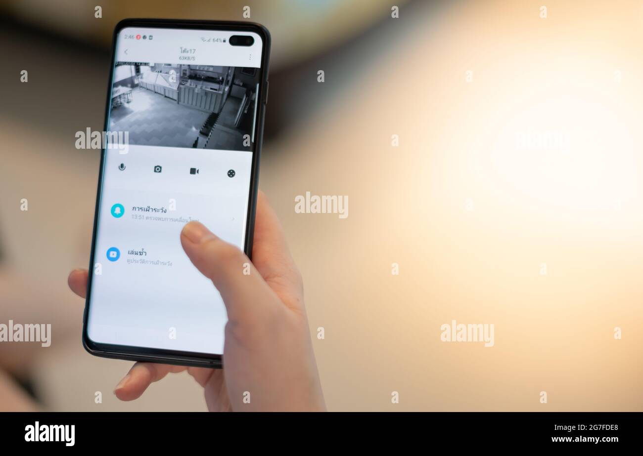 Female hand holding smartphone for watching home security camera for ...