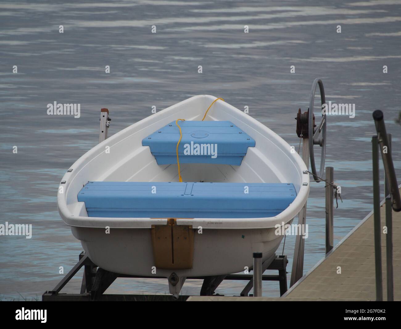 White Rowboat with Blue Seats on Boat Lift - Lake Life Stock Photo - Alamy