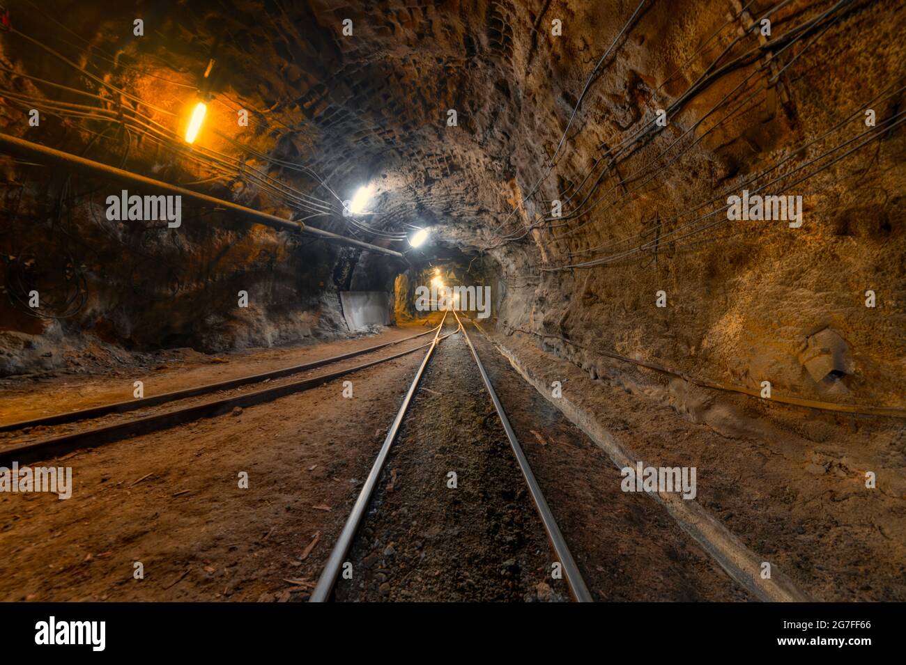 Tunnel of the mining of an underground mine. Lots of pipelines on the ...