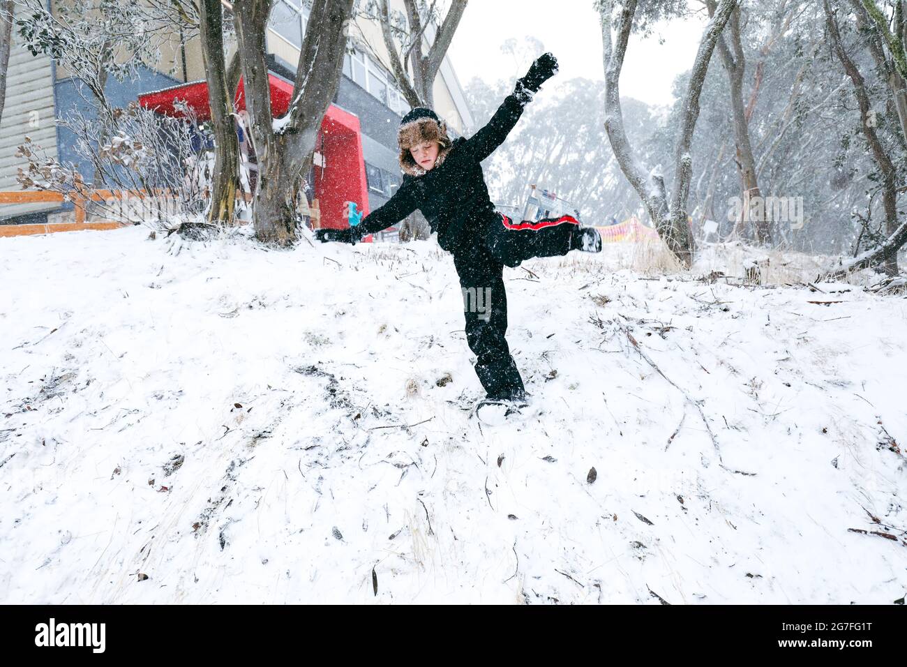 Happy boy playing in snowstorm at Mount Buller ski resort in Austra ...