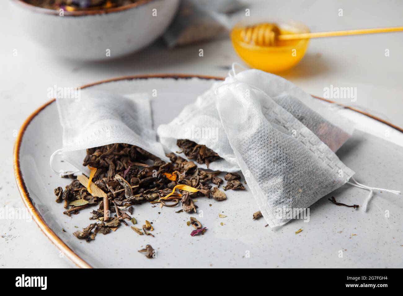 Tea bags with dry leaves on light background Stock Photo - Alamy