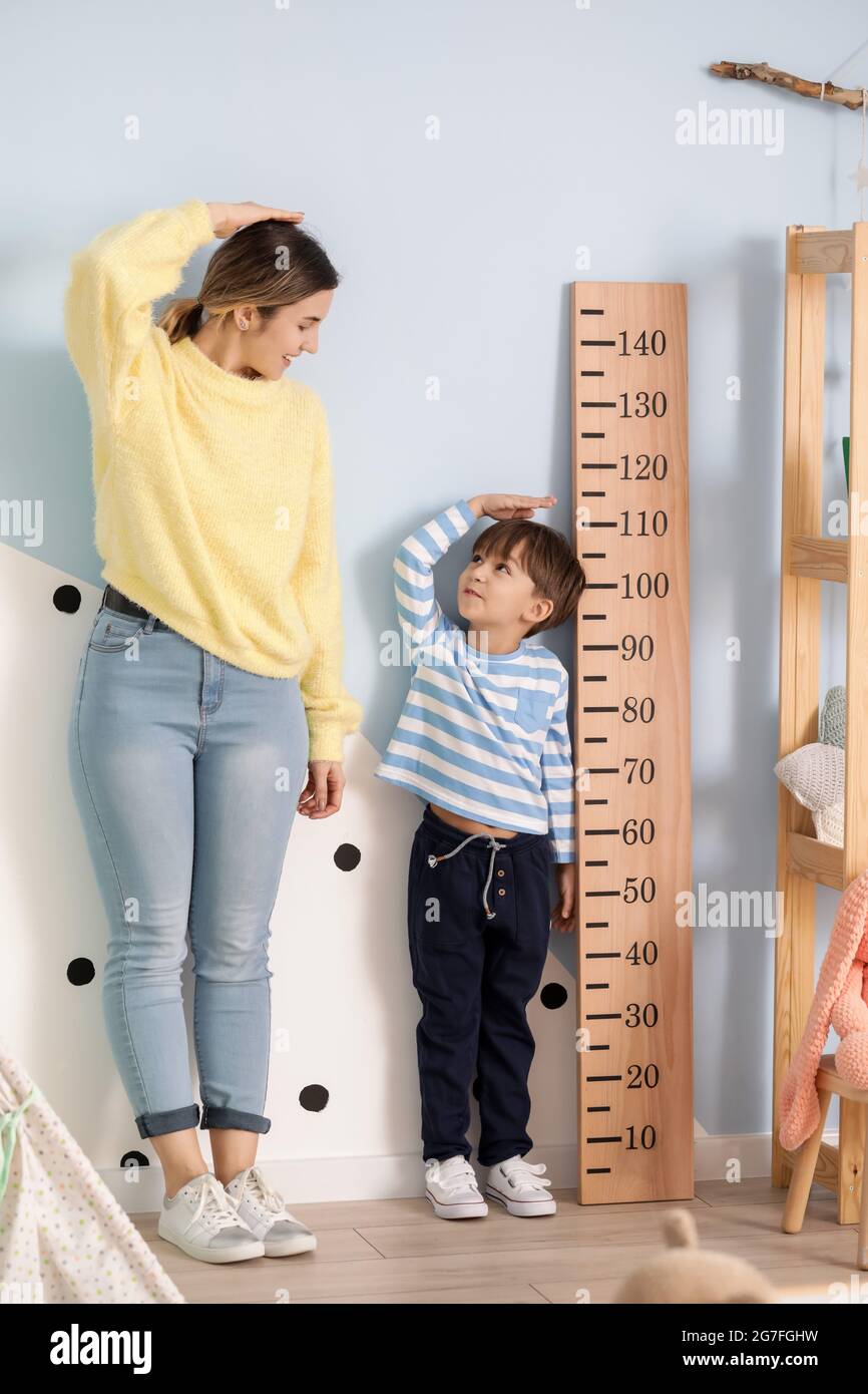 Little boy and his mother measuring height at home Stock Photo - Alamy