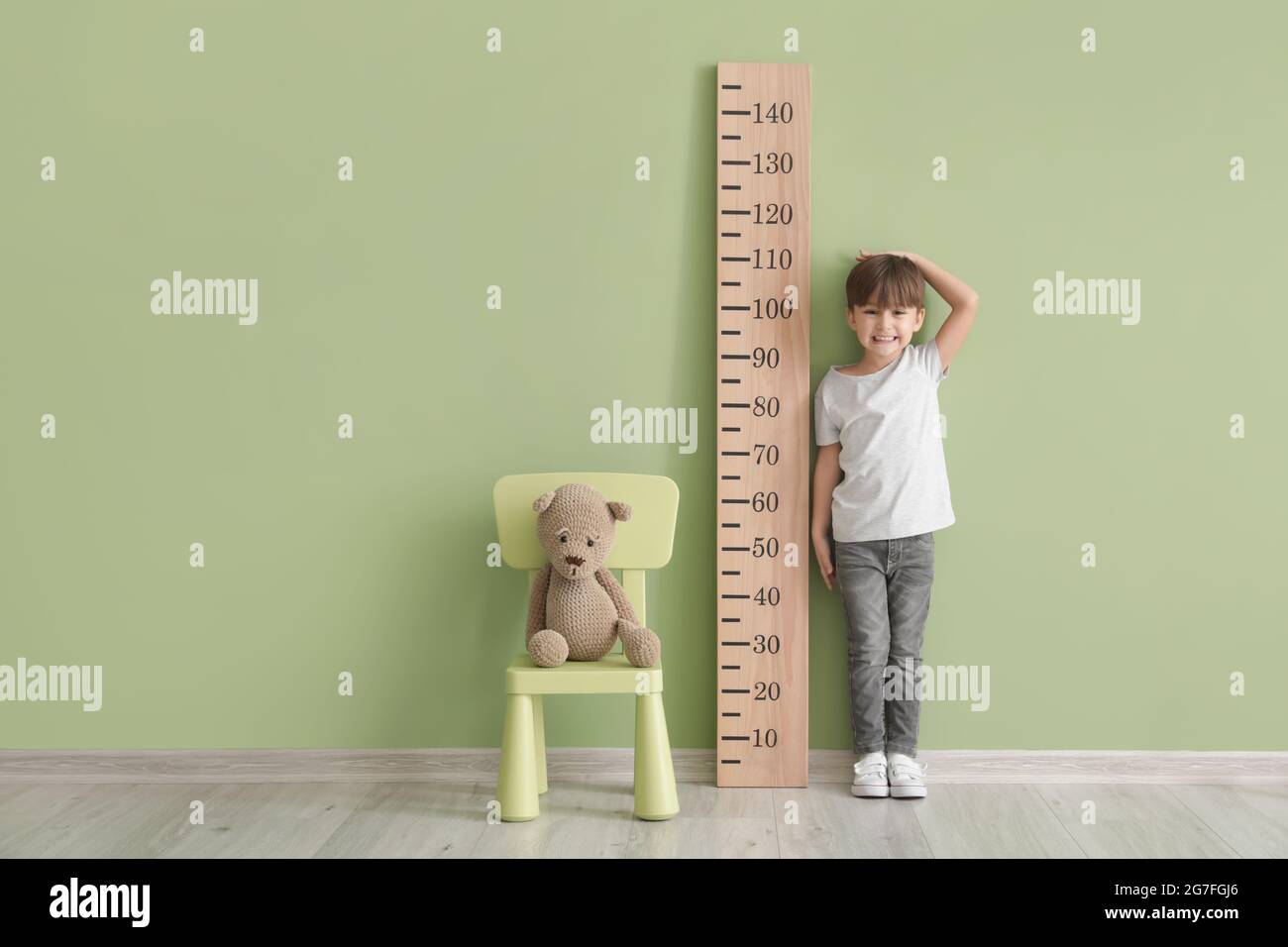 Little boy measuring height near color wall Stock Photo - Alamy