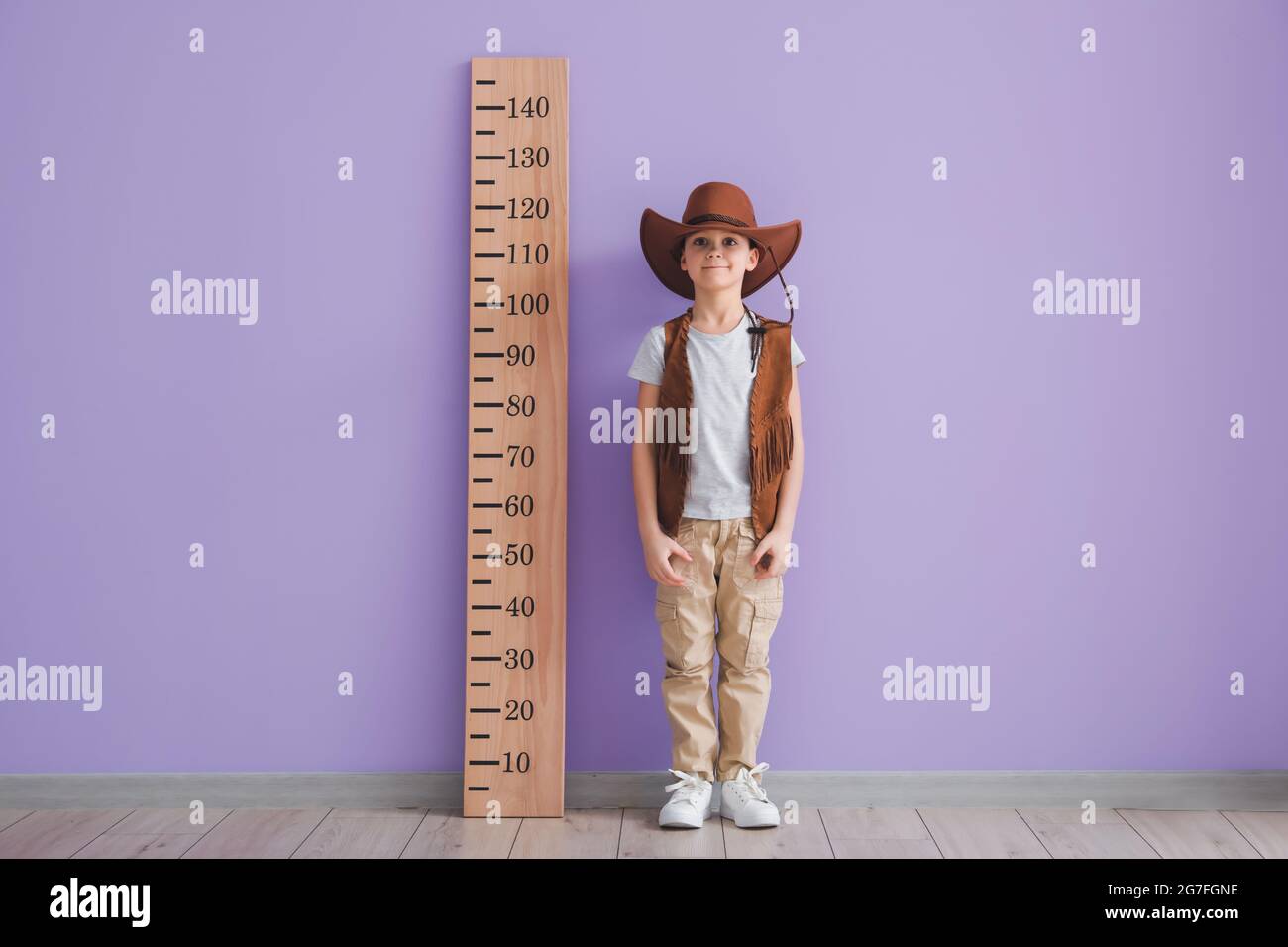 Little boy measuring height near color wall Stock Photo - Alamy