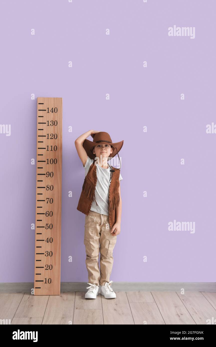 Little boy measuring height near color wall Stock Photo - Alamy