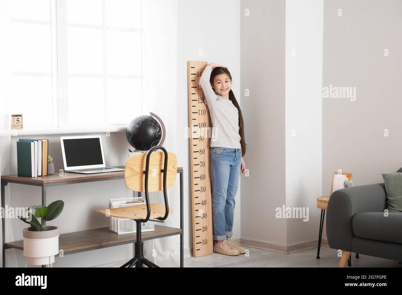 Little girl measuring height at home Stock Photo - Alamy