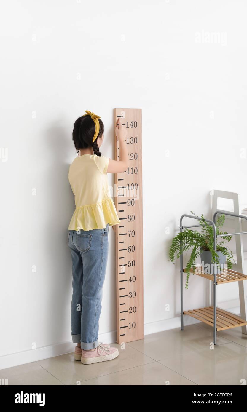 Little girl measuring height at home Stock Photo - Alamy