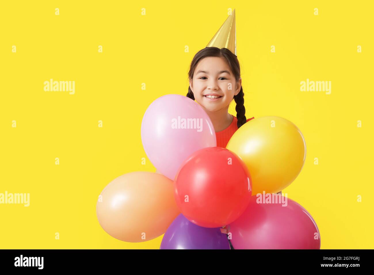 Cute little girl with balloons celebrating Birthday on color background ...