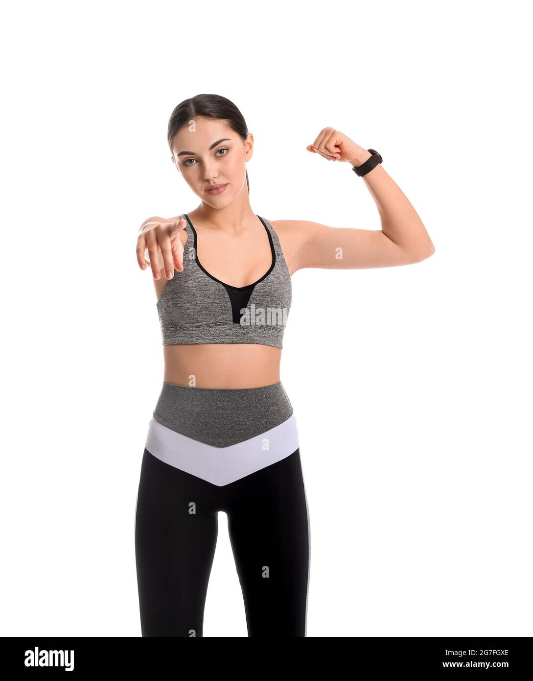 Sporty female coach pointing at viewer on white background Stock Photo ...
