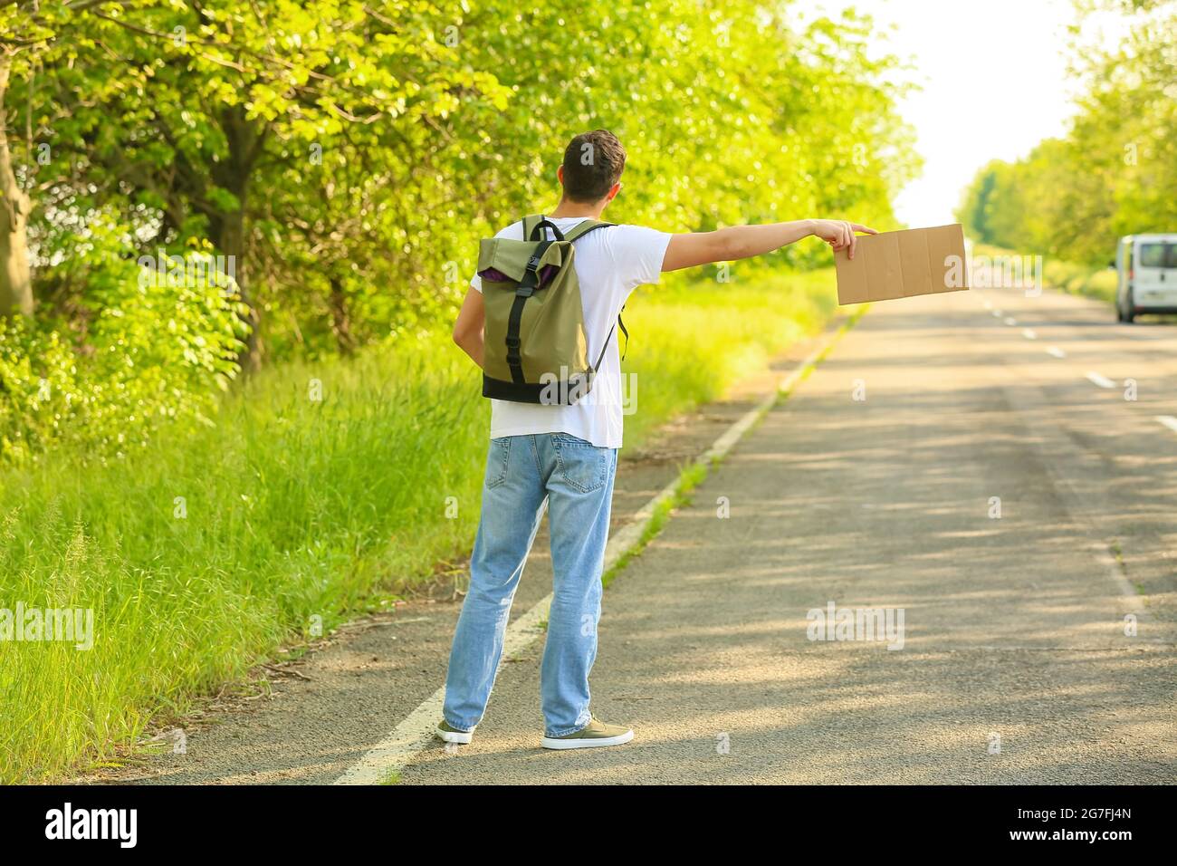 Young man hitchhiking on summer hi-res stock photography and images - Alamy