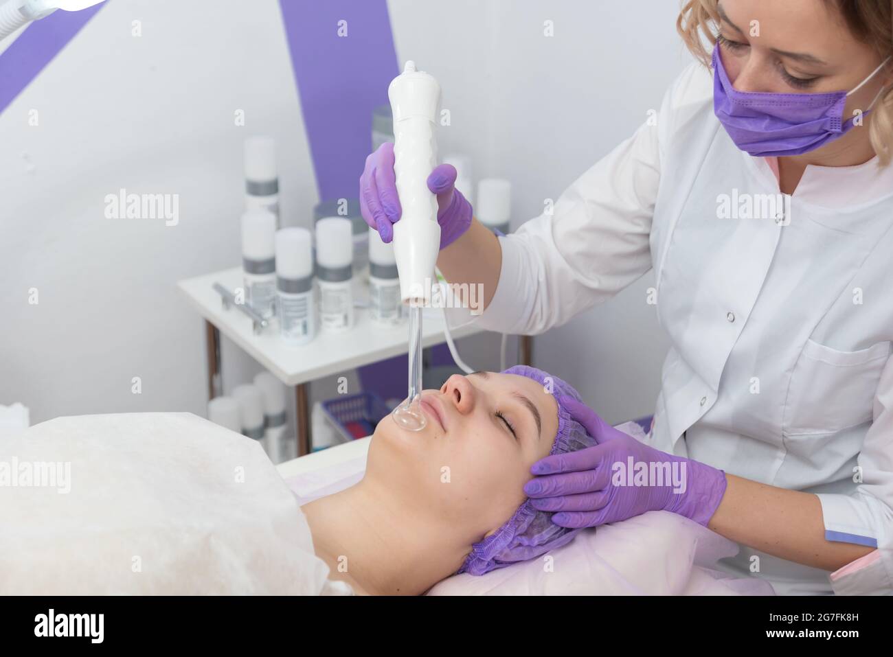 Beauty salon. The cosmetologist makes a water peeling procedure for the ...