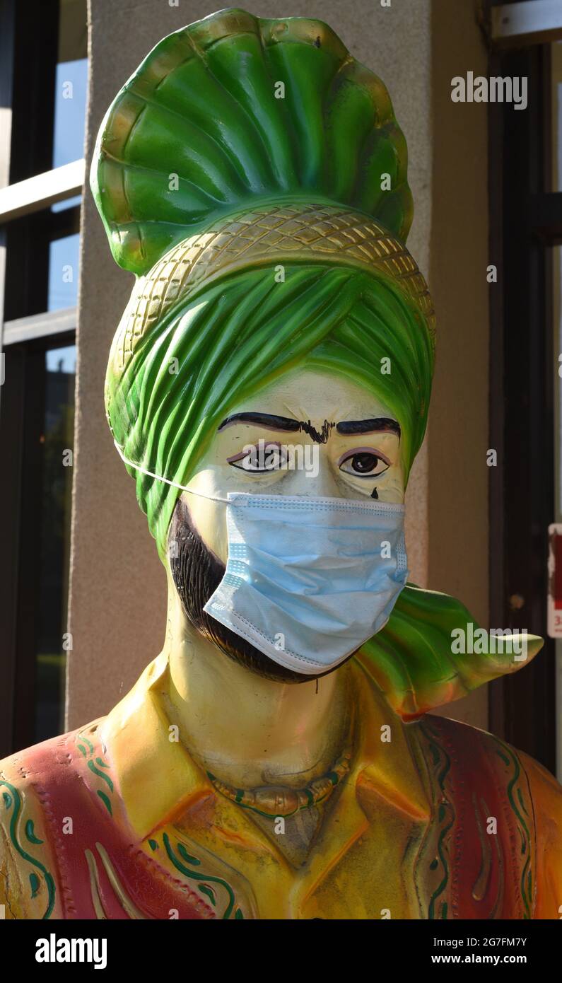 A statue of a man, dressed in clothing from India including a turban ...