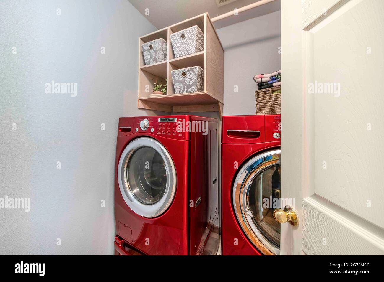 Small laundry room interior with red laundry machines Stock Photo - Alamy