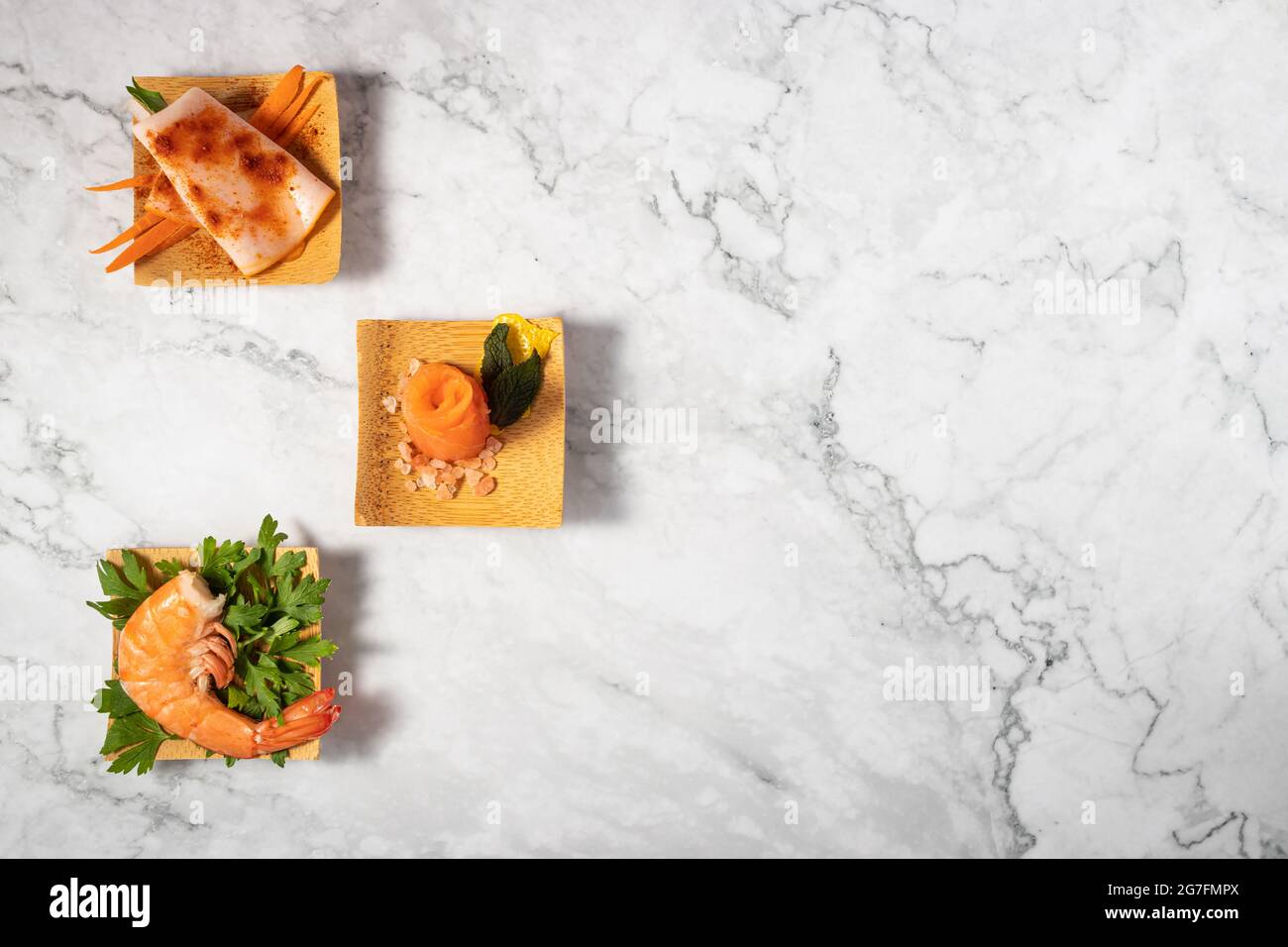 Top view of delicious appetizers on a small wooden plate on a marble ...
