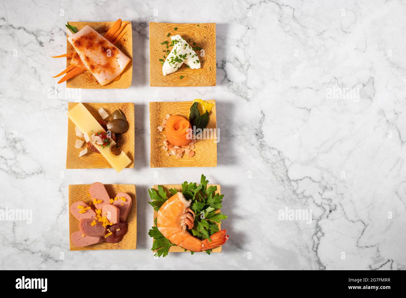 Top view of six delicious appetizers on a small wooden plate on a ...