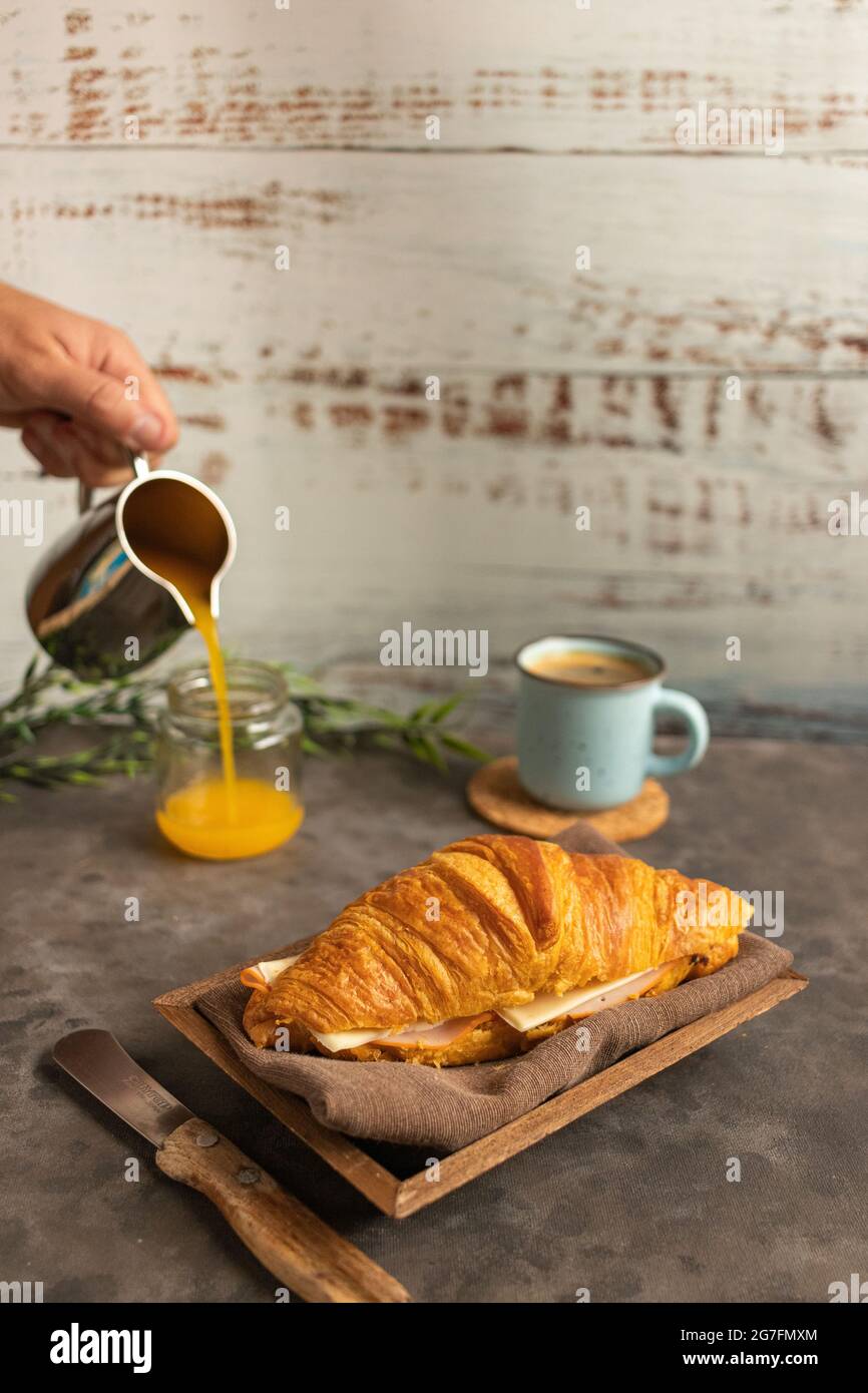 Crunchy delicious croissant with ham and cheese filling, a mug of hot ...